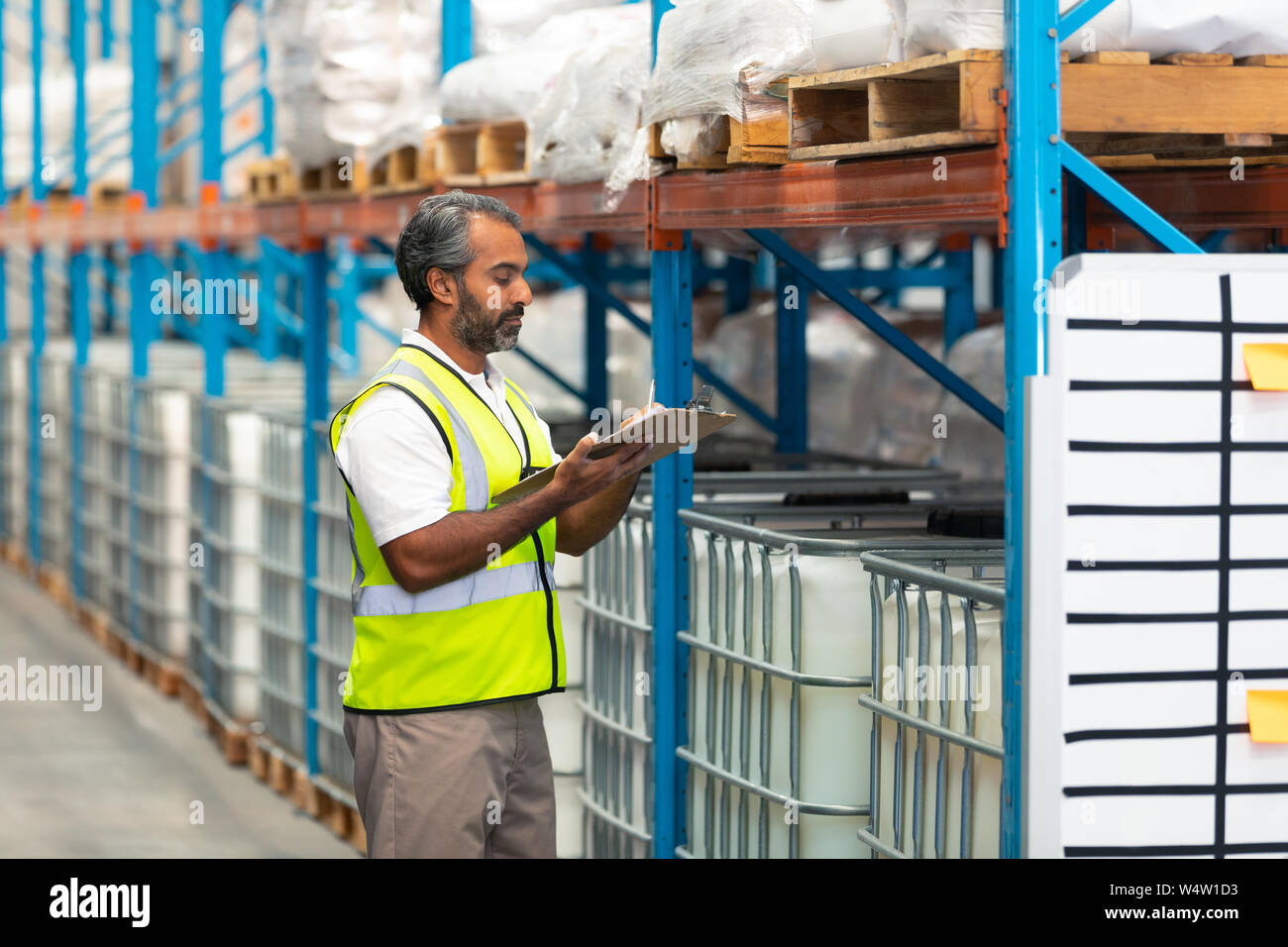 Male worker checking stocks in warehouse Stock Photo - Alamy