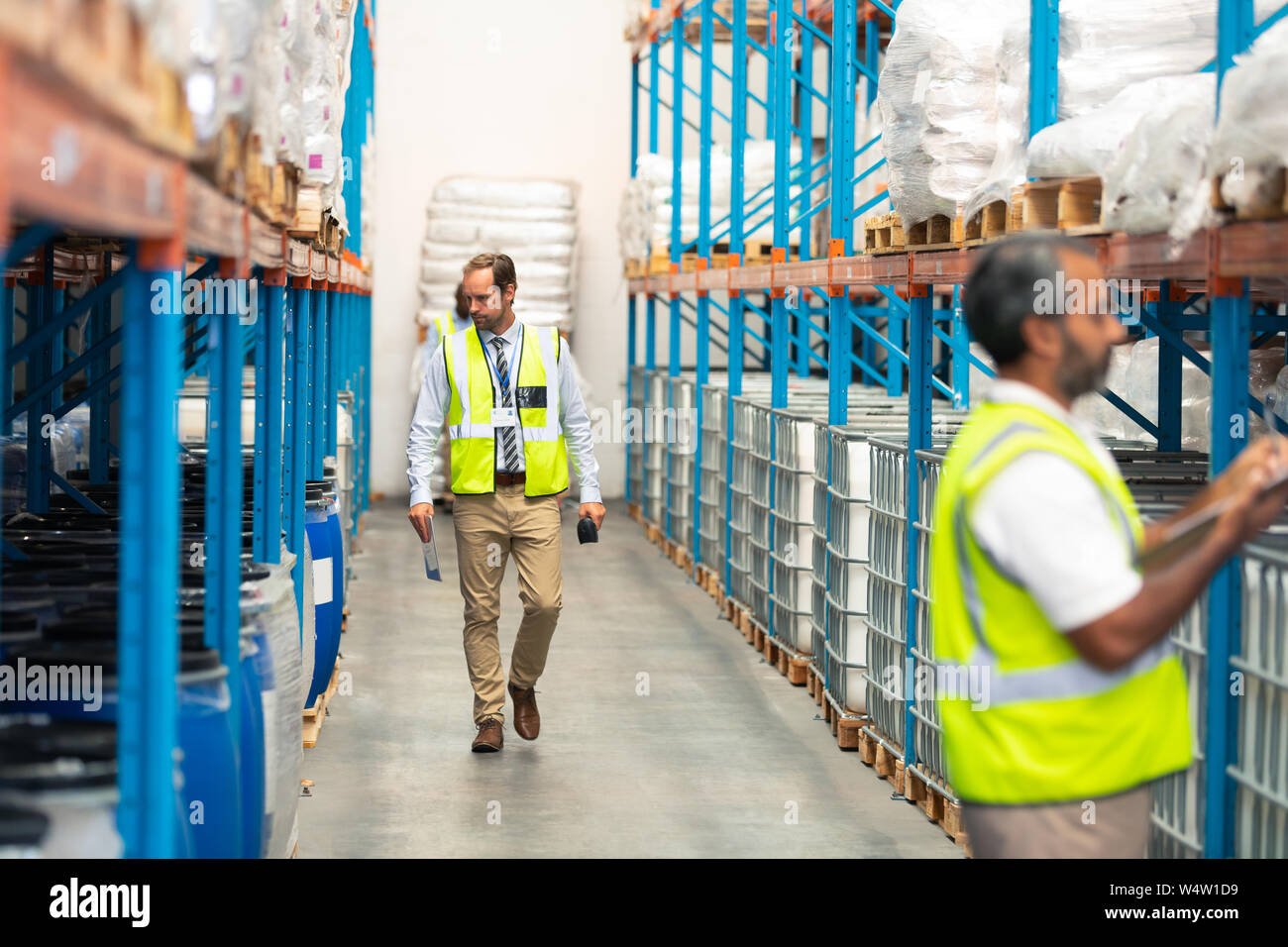 Male supervisor walking in warehouse Stock Photo - Alamy