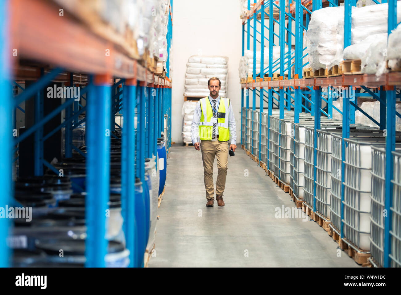 Male supervisor walking in warehouse Stock Photo - Alamy