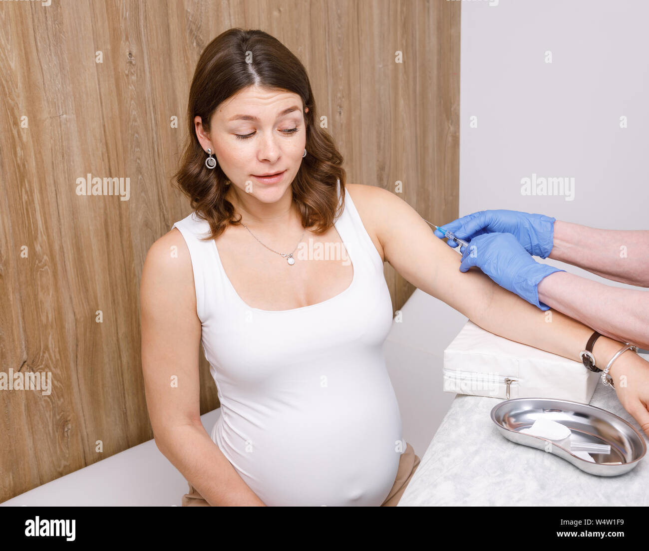 Medical assistant giving an intramuscular injection of a vaccine to arm ...