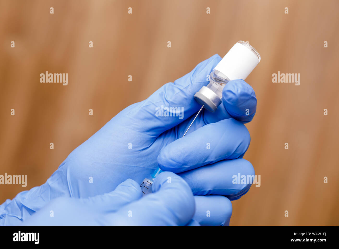 Close-up shot of medical assistant wearing protective gloves preparing ...