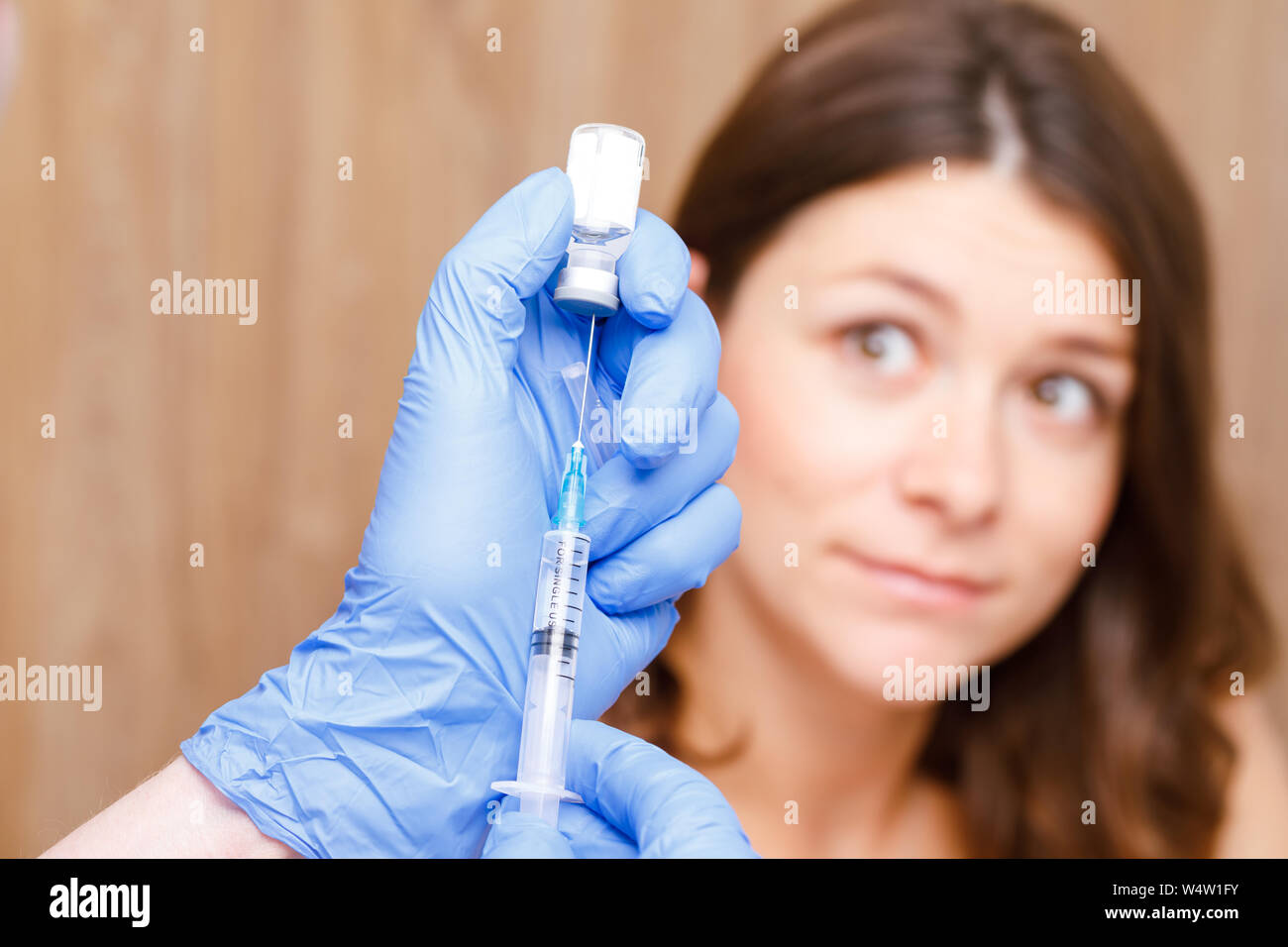 Medical assistant preparing an intramuscular injection of a vaccine in ...