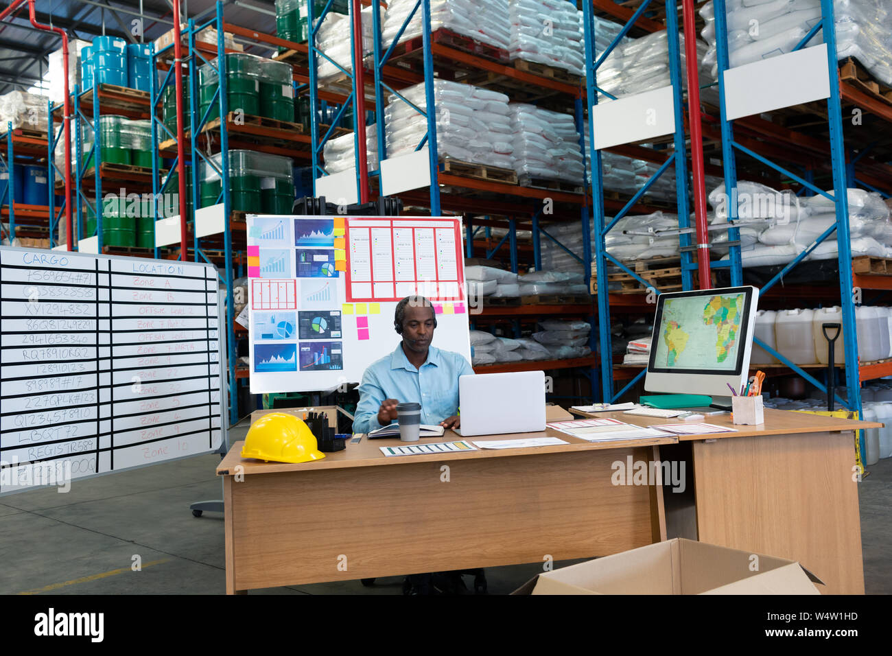 Male supervisor working on laptop at desk Stock Photo - Alamy