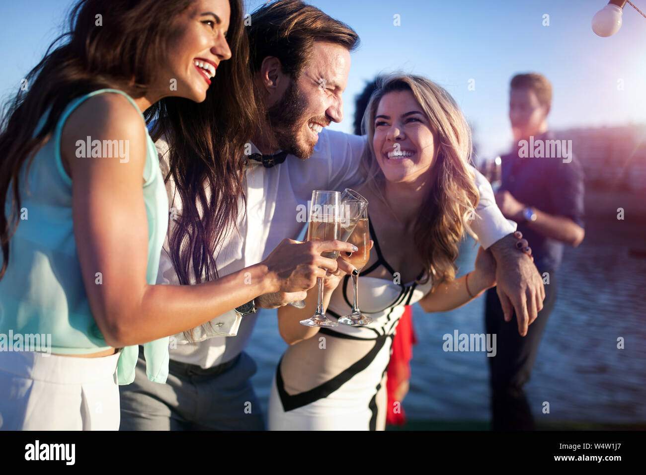 Group of happy friends partying and toasting drinks Stock Photo - Alamy