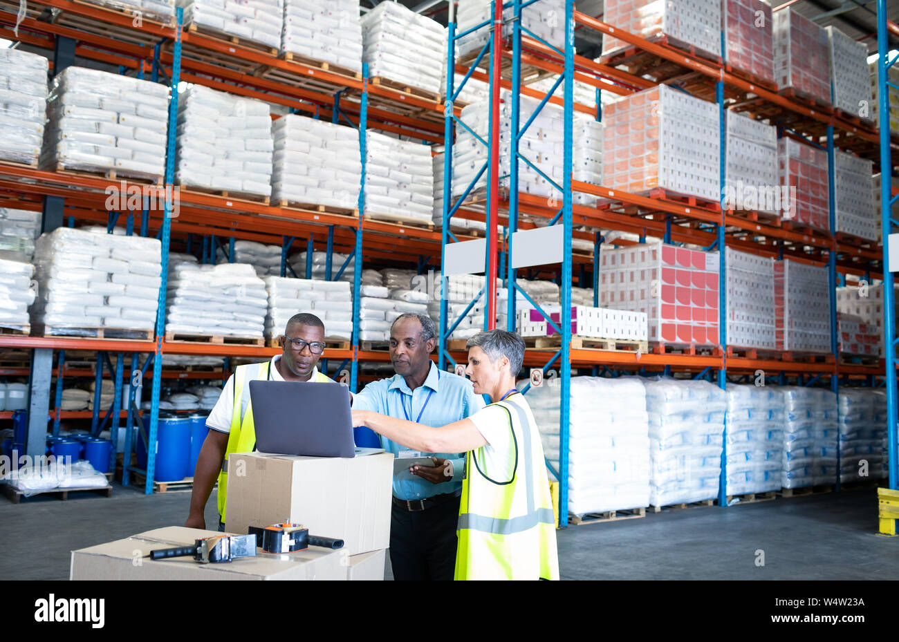 Warehouse staffs discussing over laptop in warehouse Stock Photo - Alamy