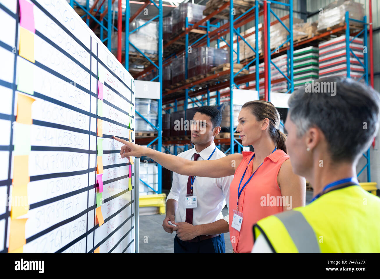 Warehouse staffs discussing over whiteboard in warehouse Stock Photo ...