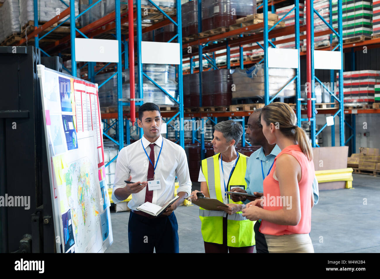 Warehouse staffs discussing over whiteboard in warehouse Stock Photo ...