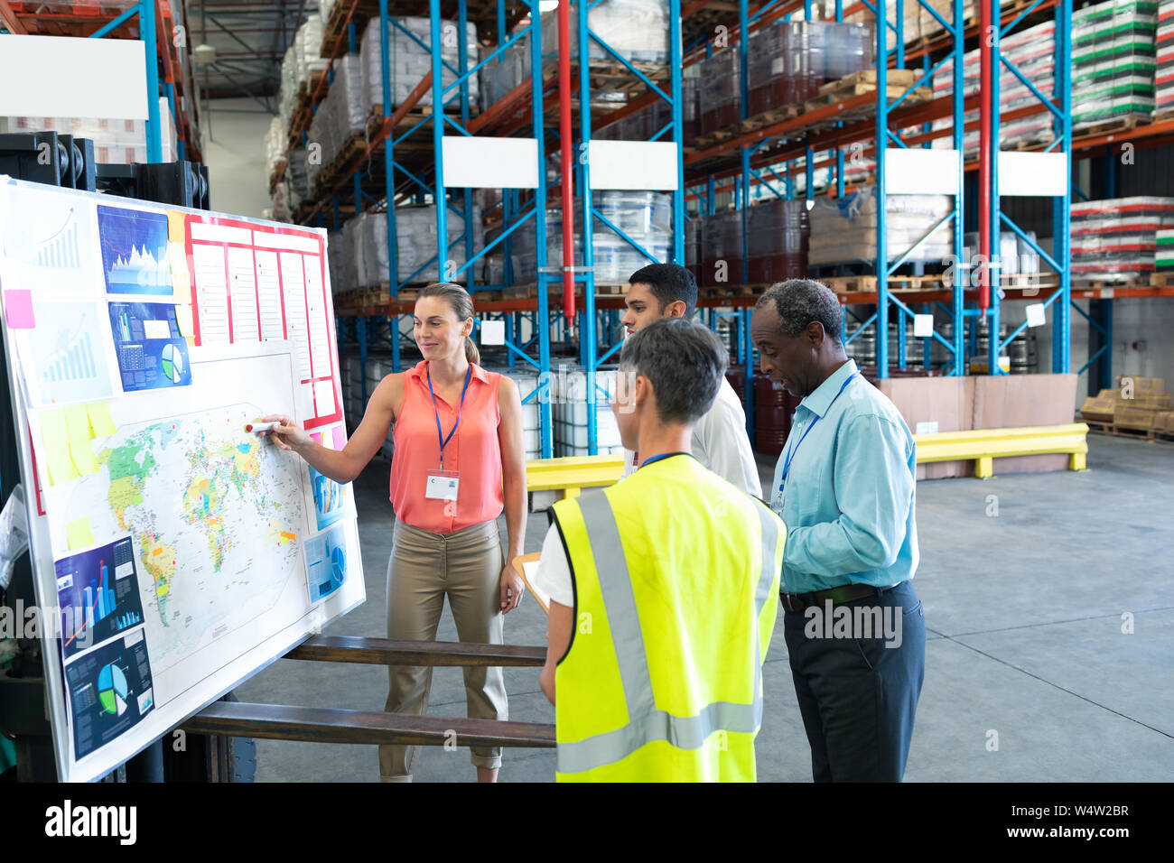 Warehouse staffs discussing over whiteboard in warehouse Stock Photo ...