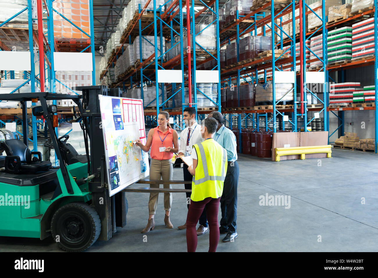 Warehouse staffs discussing over whiteboard in warehouse Stock Photo ...