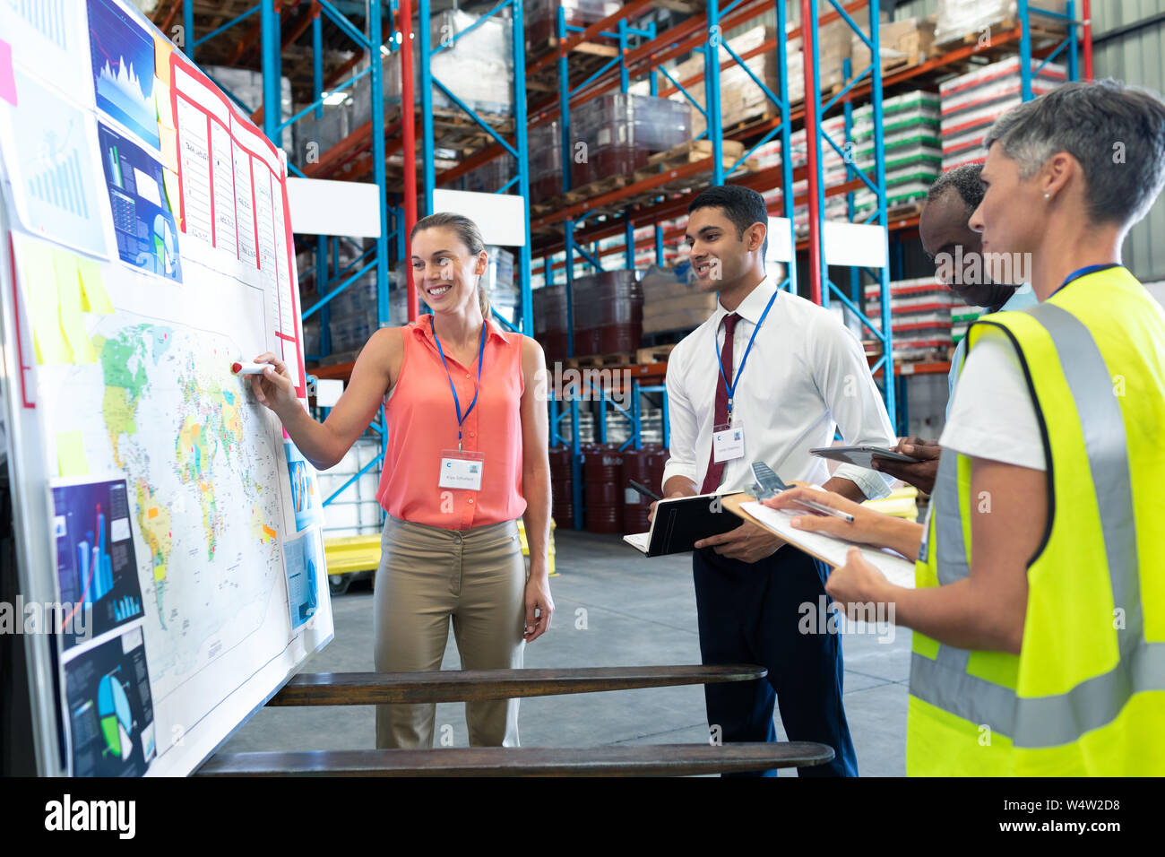 Warehouse staffs discussing over whiteboard in warehouse Stock Photo ...