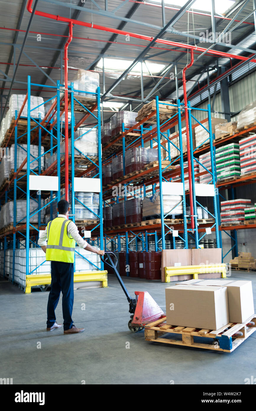 Male staff using pallet jack in warehouse Stock Photo - Alamy
