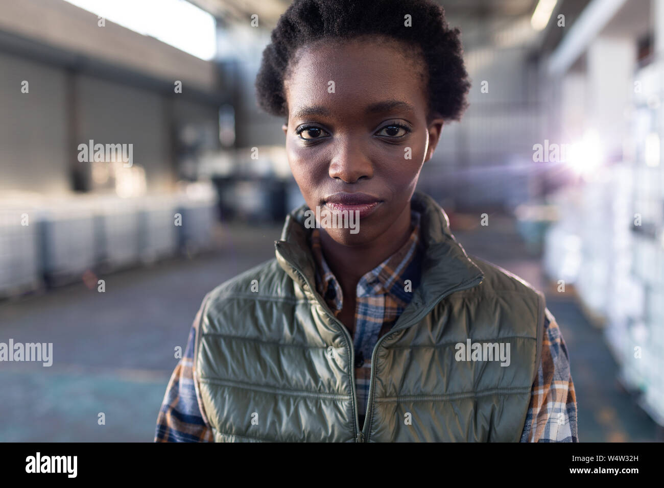 Female staff standing with arms crossed in warehouse Stock Photo - Alamy