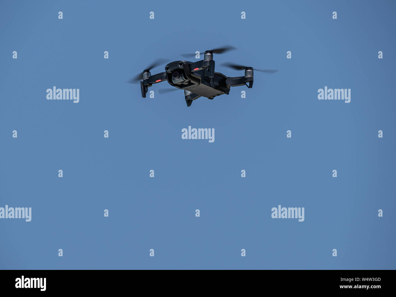 drone moving the blades flying through the blue sky Stock Photo - Alamy