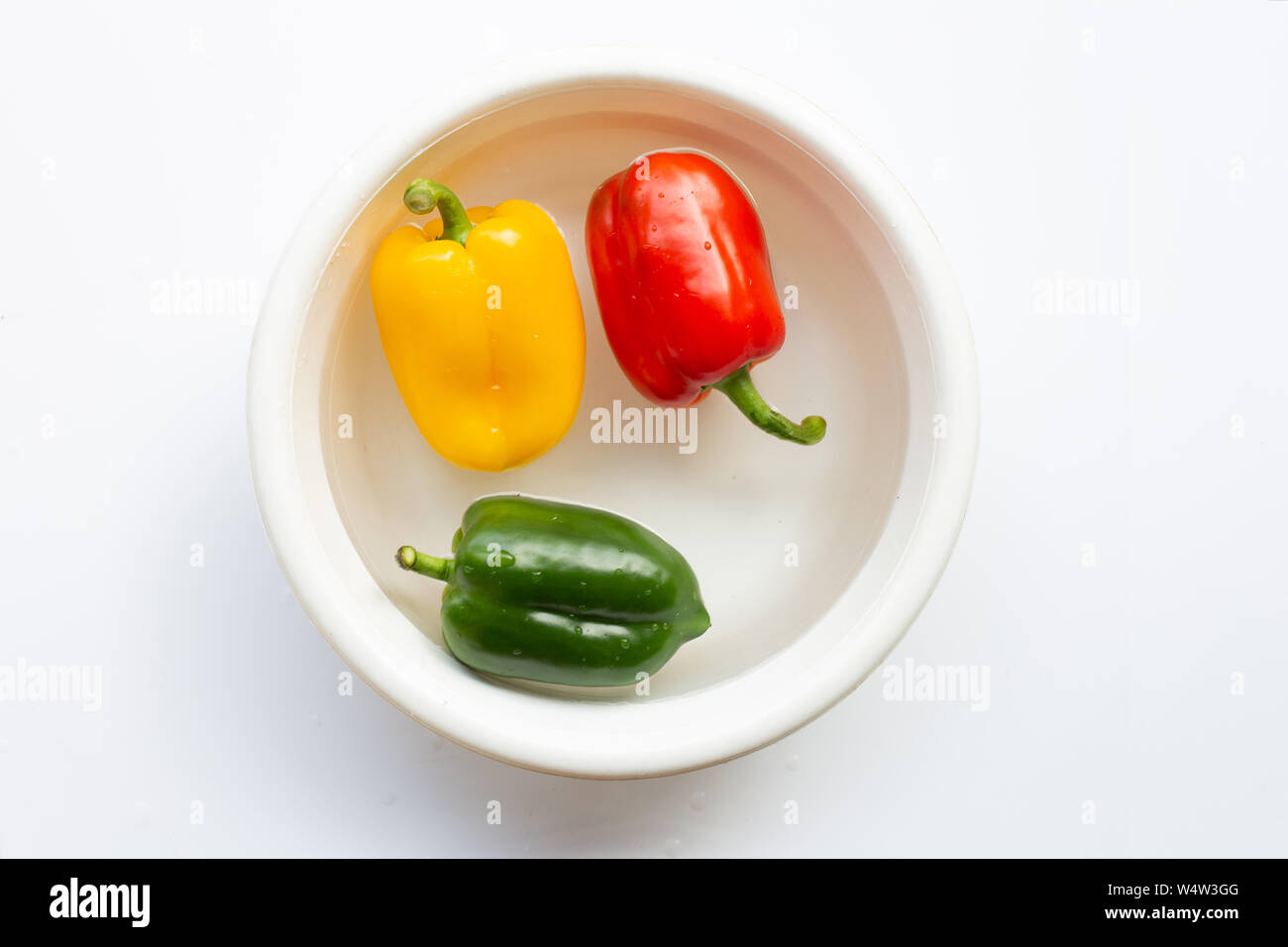Bell pepper soaked in water. Washing fresh vegetables on white ...