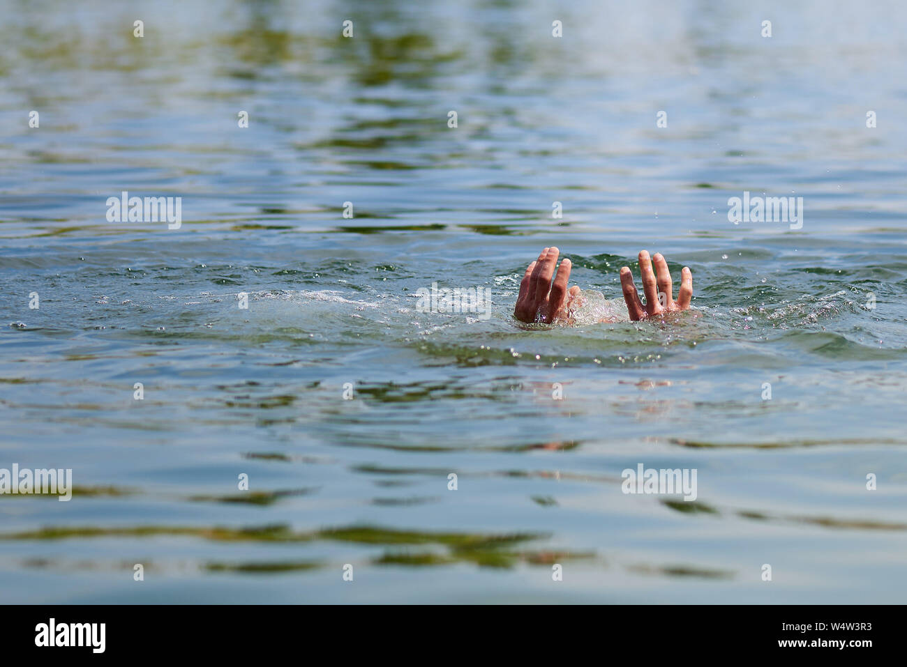 Hands with splashes of water drowning man.Сopy space Stock Photo - Alamy