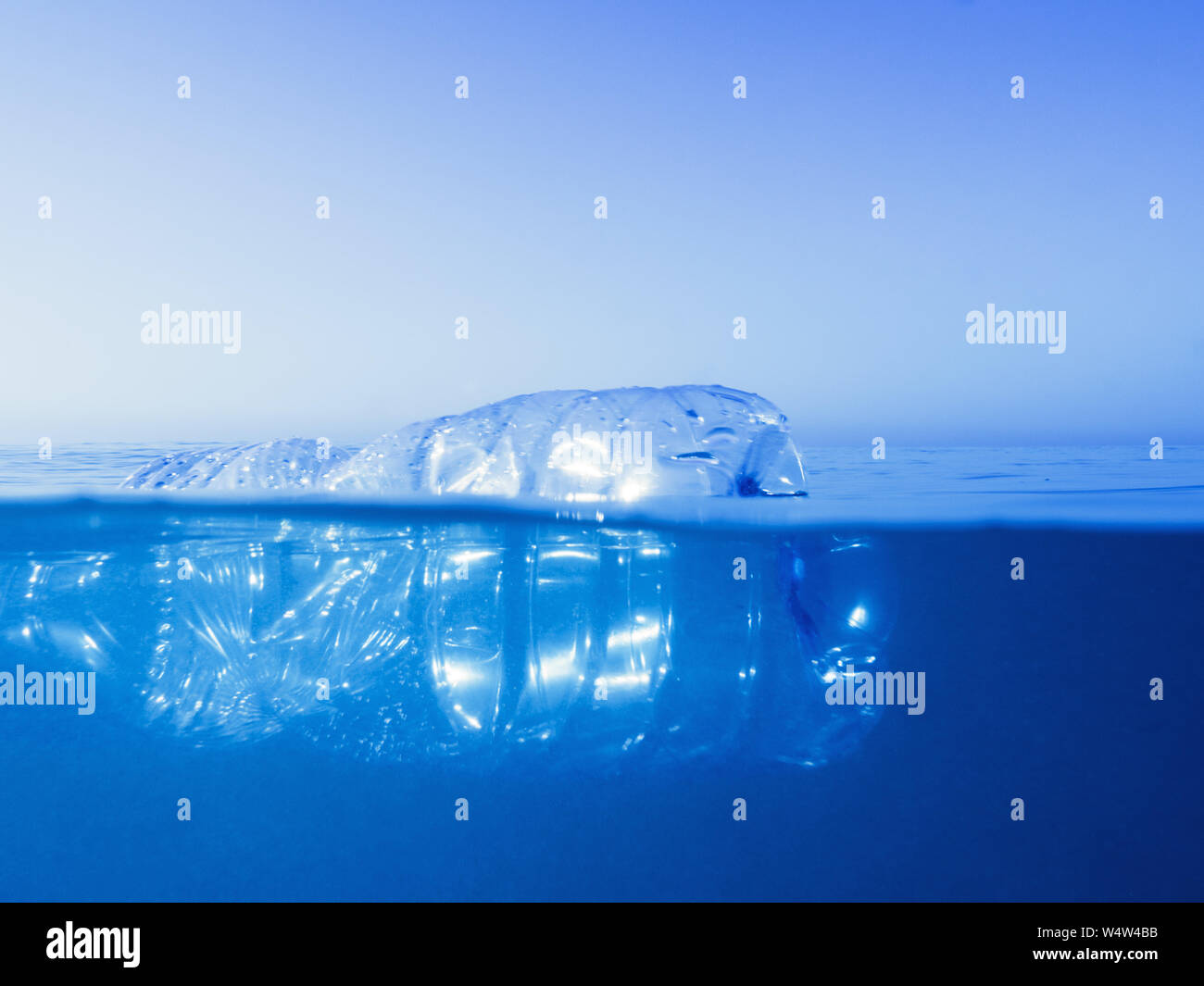 plastic waste at the ocean, photo half surface half underwater of a ...