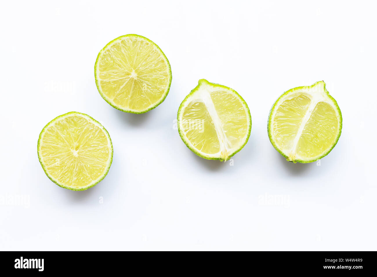 Ripe limes with green leaves on white background Stock Photo - Alamy