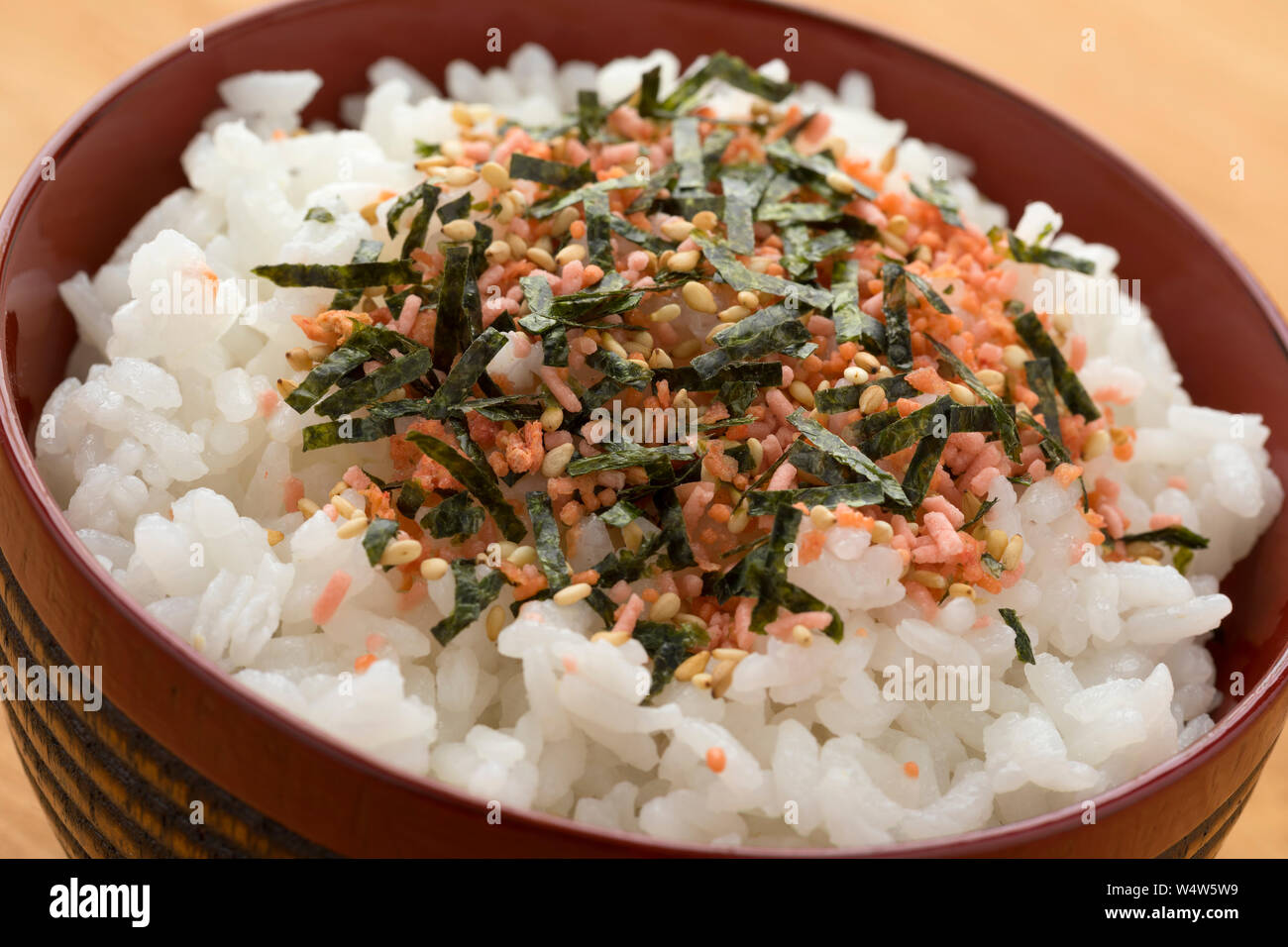 Traditional lacquered Japanese bowl with cooked white rice and furikake ...