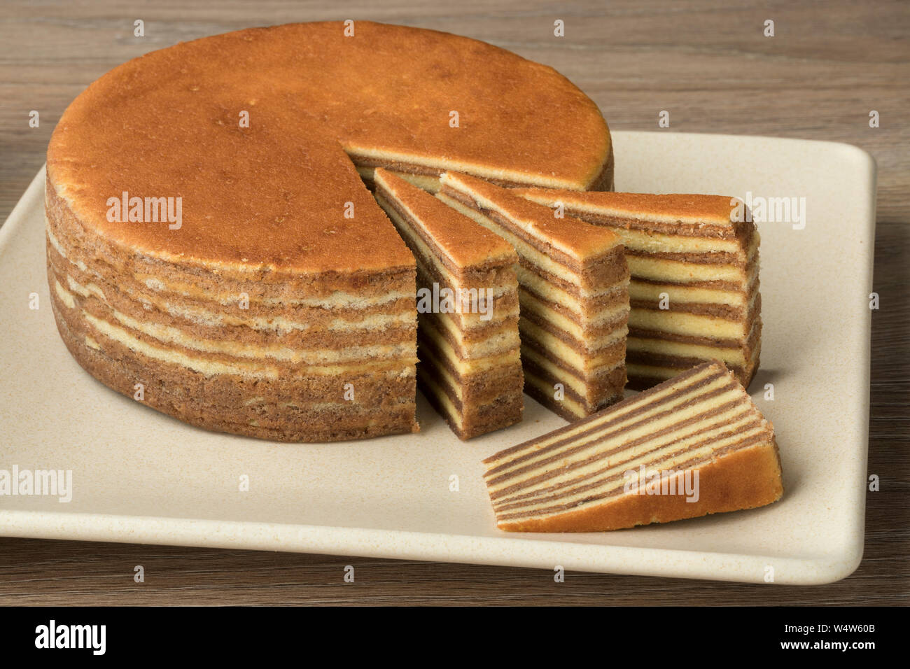 Dish with Asian homemade layer cake and a piece Stock Photo - Alamy