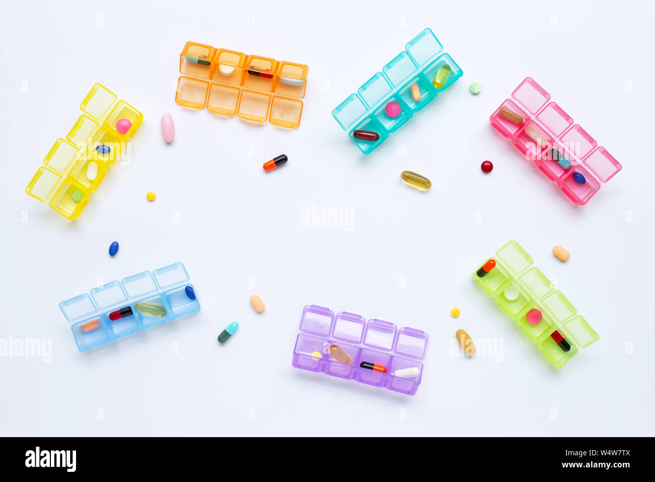 Many colored tablets and capsules with pill box isolated on white ...