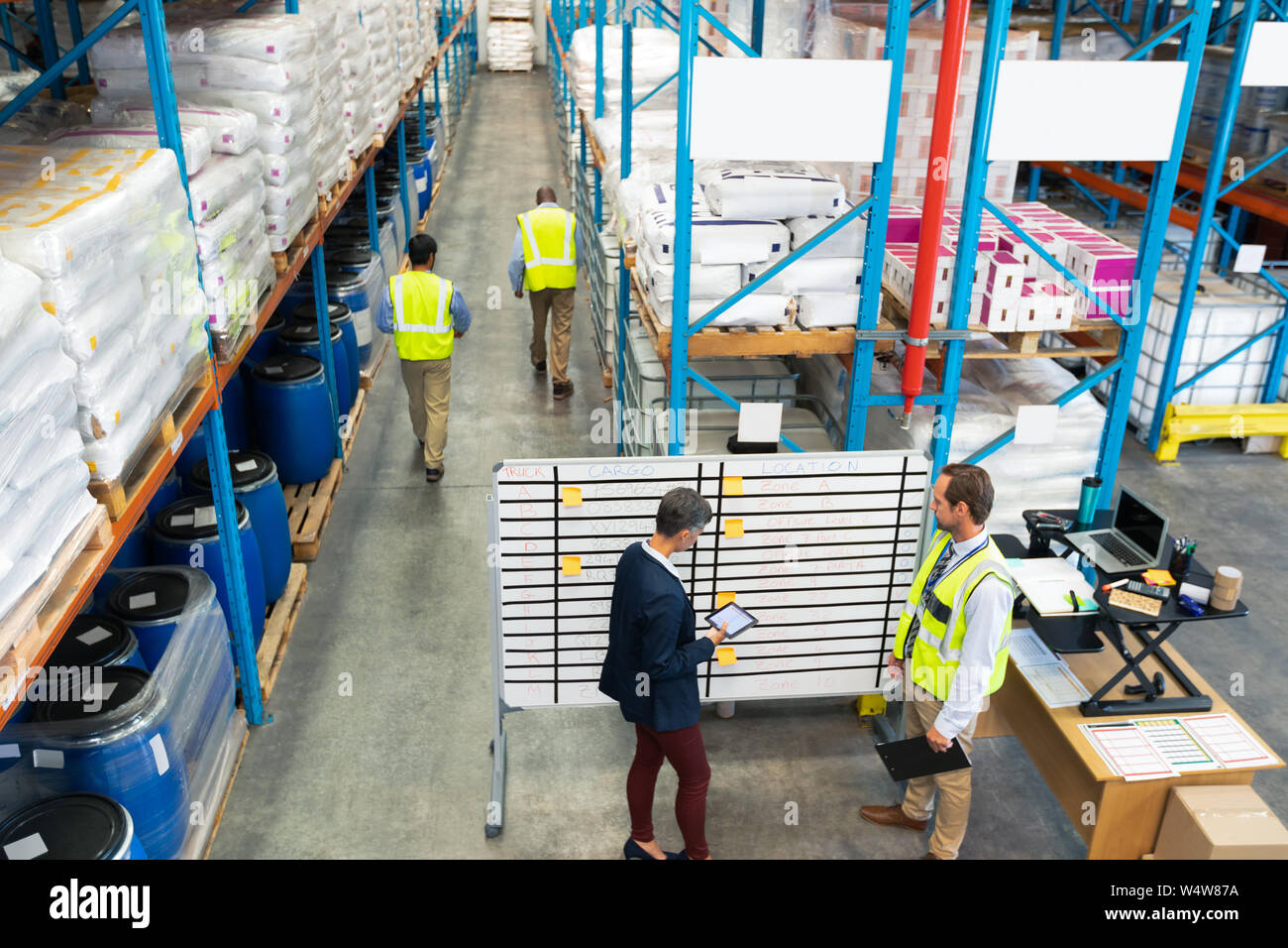 Warehouse staff discussing over whiteboard in warehouse Stock Photo - Alamy