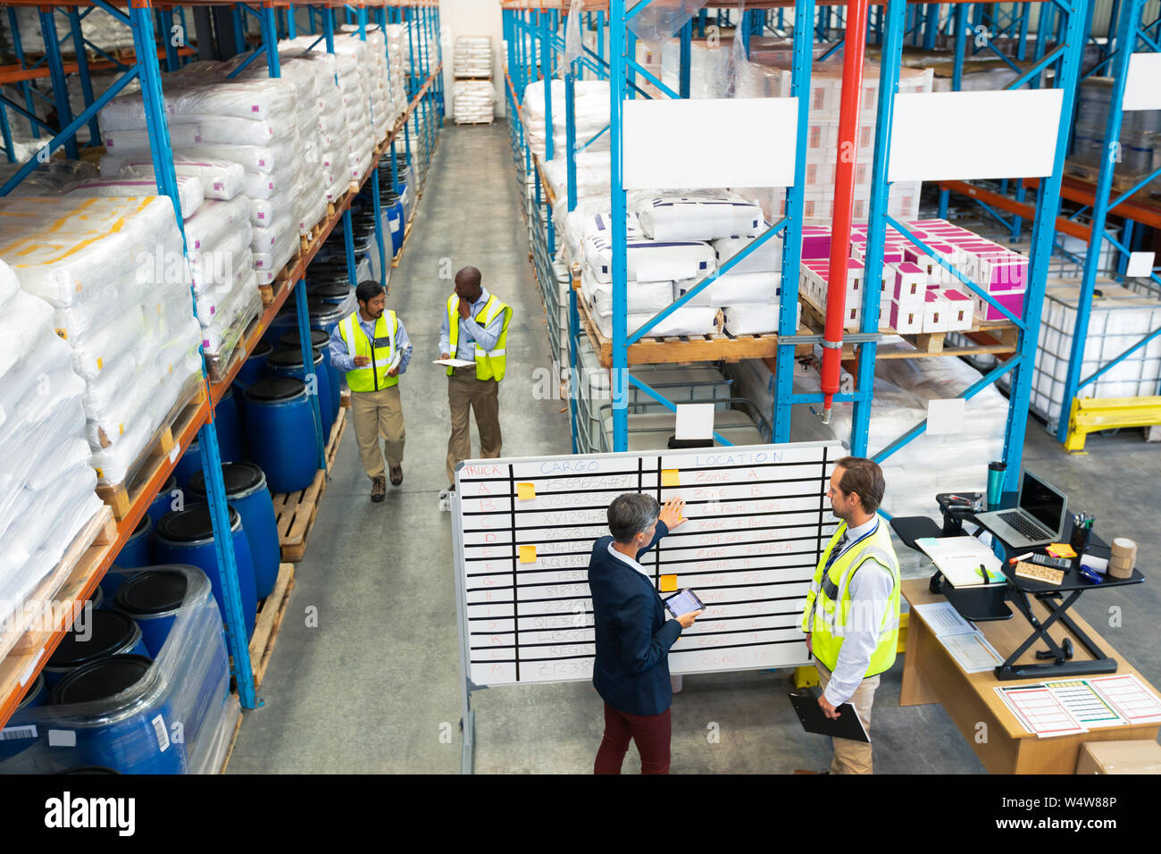 Warehouse staff discussing over whiteboard in warehouse Stock Photo - Alamy