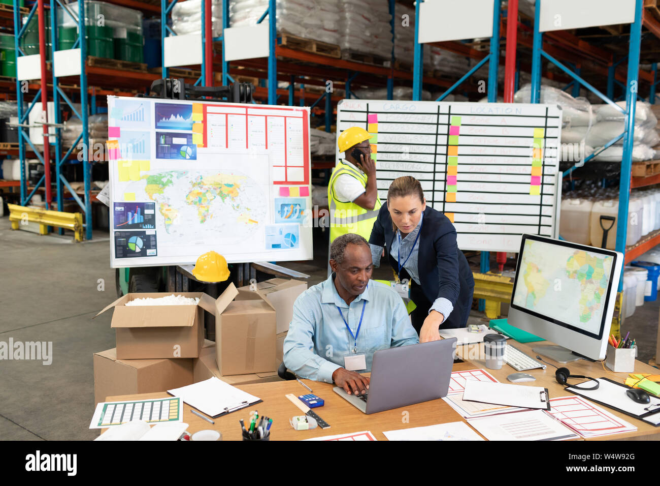 Female manager and male supervisor discussing over laptop at desk Stock ...