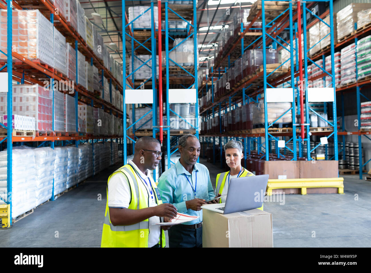 Warehouse staffs discussing over laptop in warehouse Stock Photo - Alamy