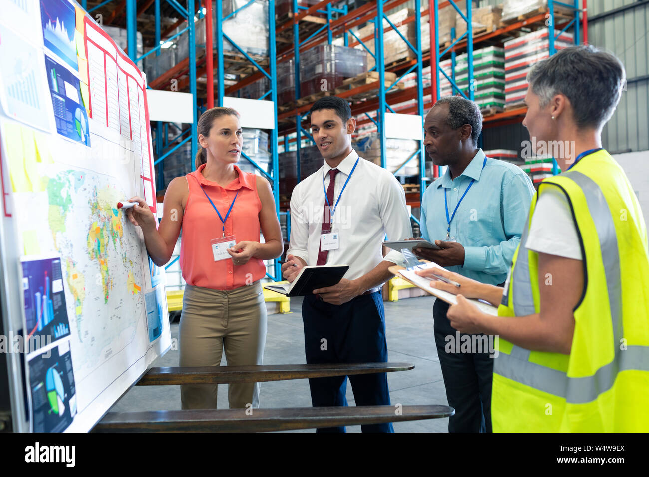 Warehouse staffs discussing over whiteboard in warehouse Stock Photo ...
