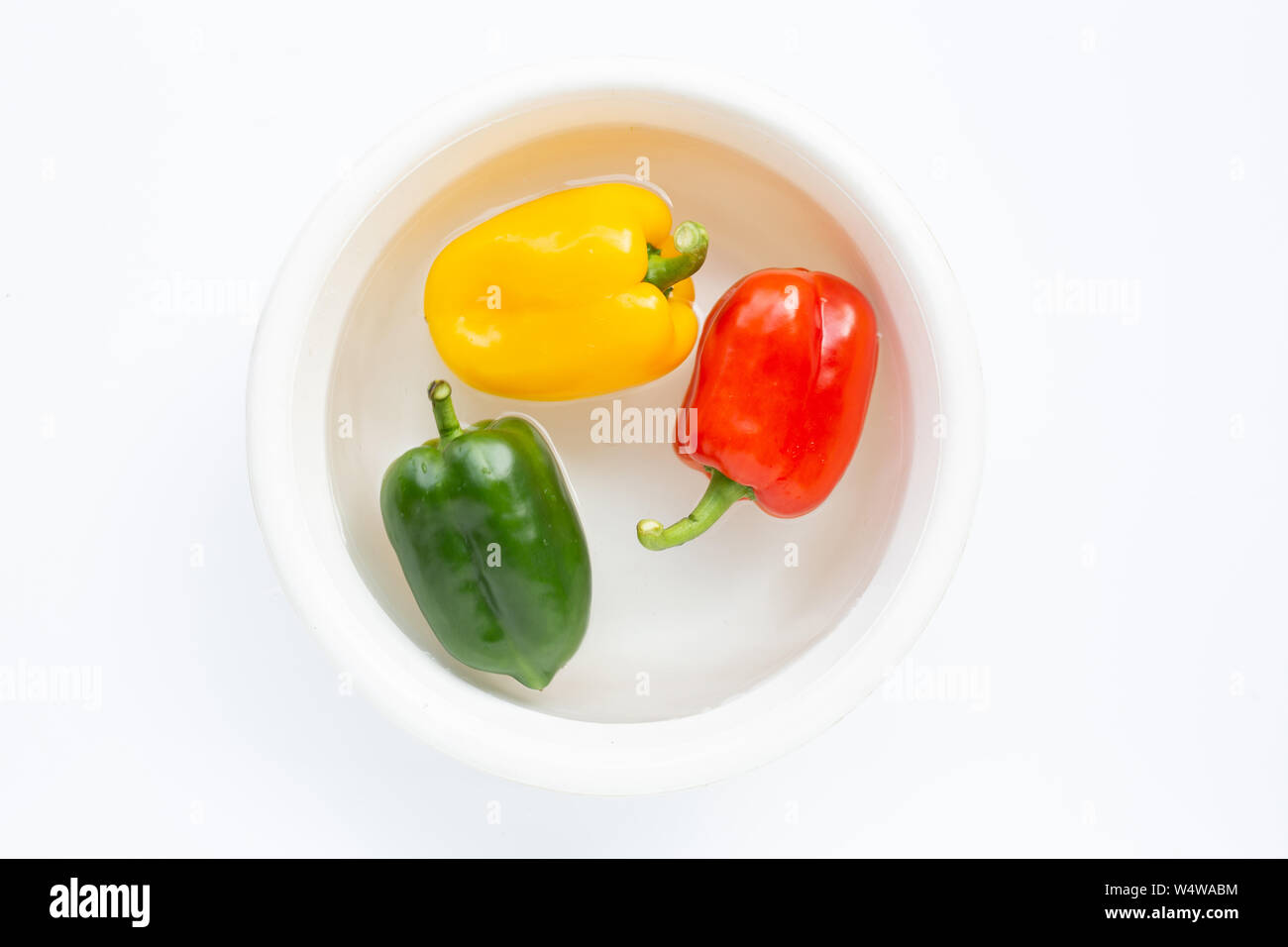 Bell pepper soaked in water. Washing fresh vegetables on white ...