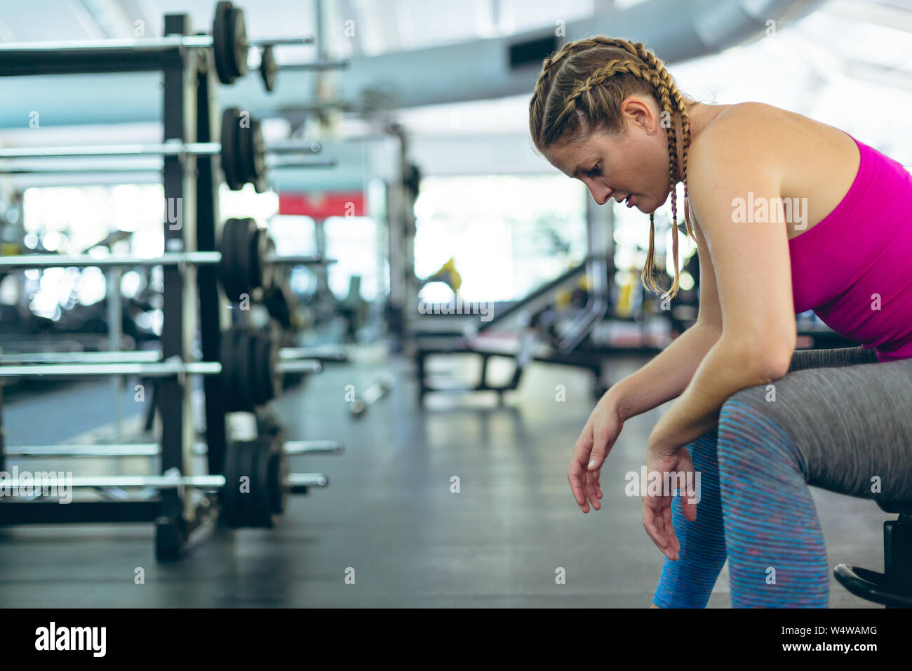 Female athletic relaxing on a bench in fitness center Stock Photo - Alamy