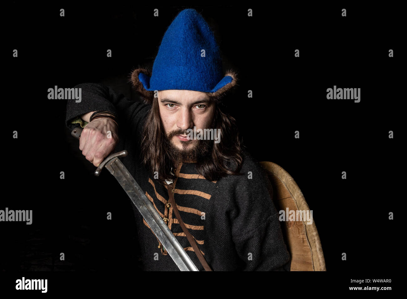 Slavic bearded warrior in a costume of the Viking Age takes the sword ...