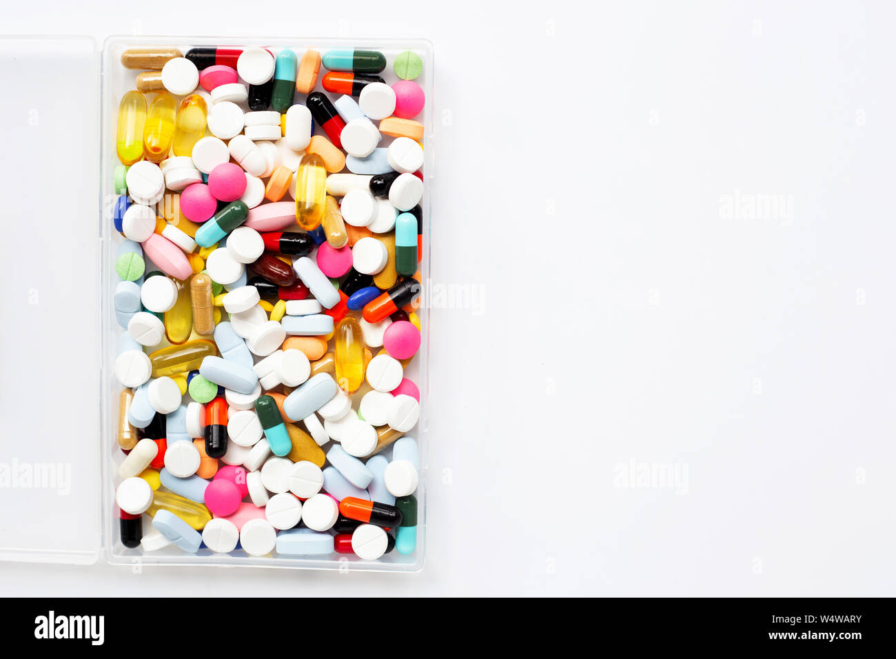 Colorful tablets with capsules and pills in plastic box on white ...