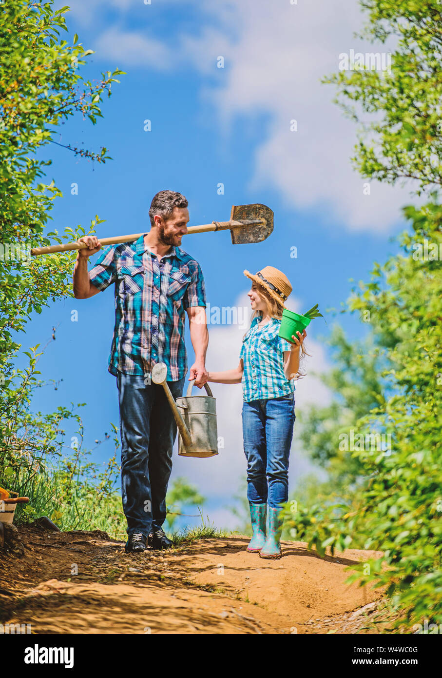 kid worker with dad hold box. family bonding. spring country side ...
