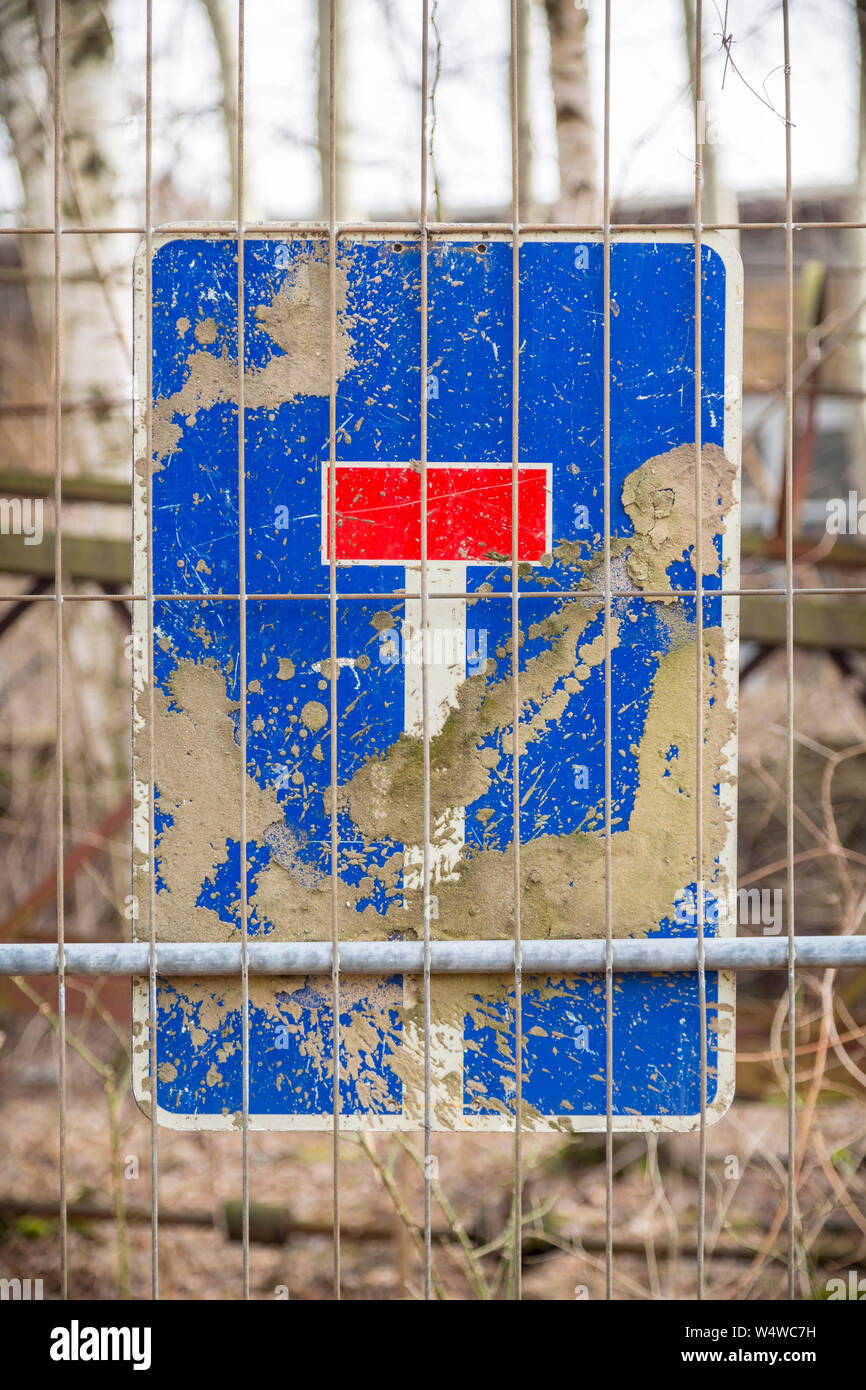 dirty german dead end traffic sign,behind a metal fence Stock Photo - Alamy