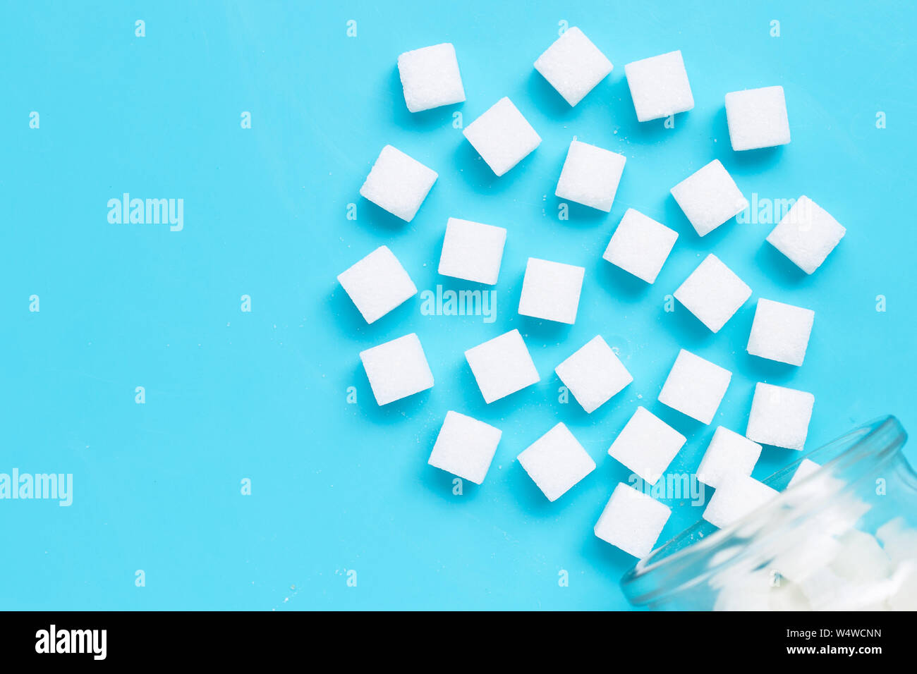 Cubes of sugar on a blue background. Copy space Stock Photo - Alamy