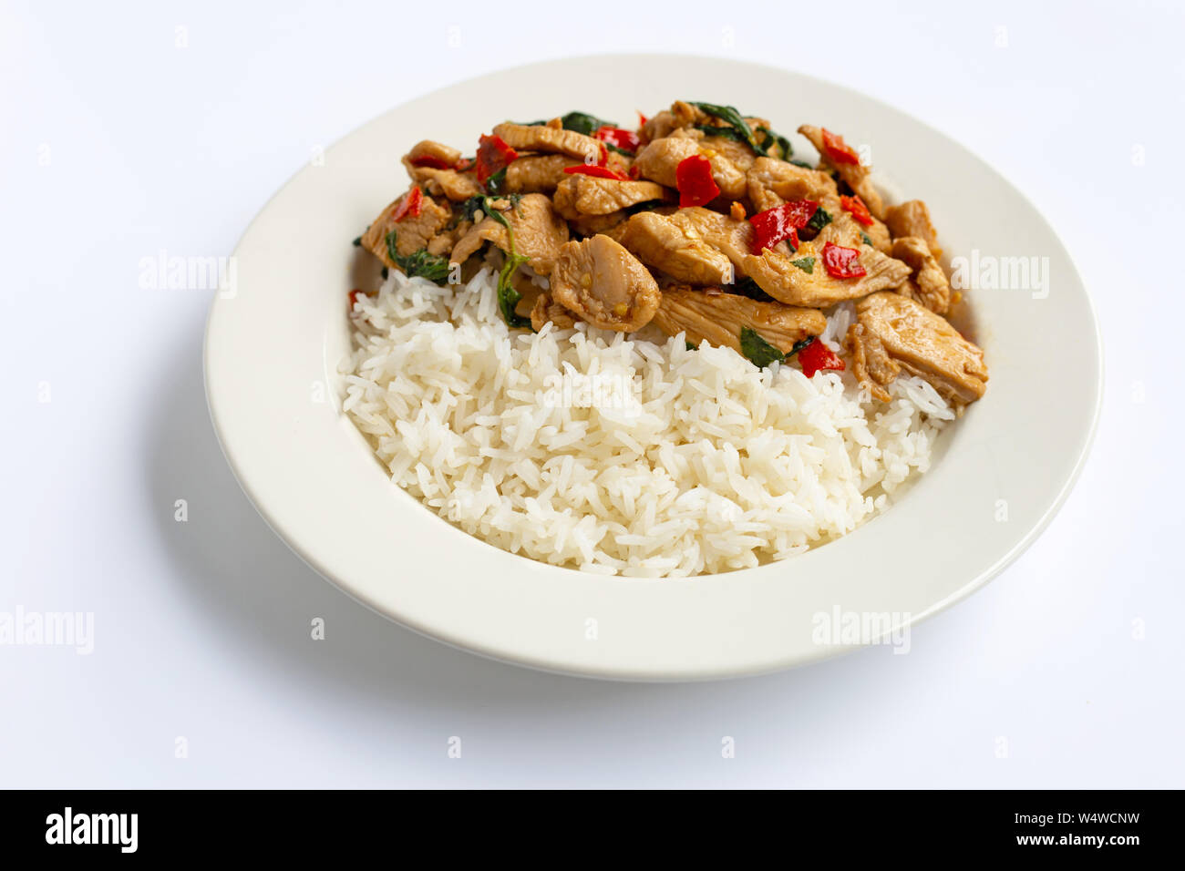 Rice topped with stir-fried chicken and holy basil on white background ...