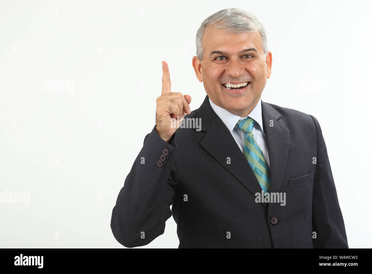 Businessman pointing upward and smiling Stock Photo - Alamy
