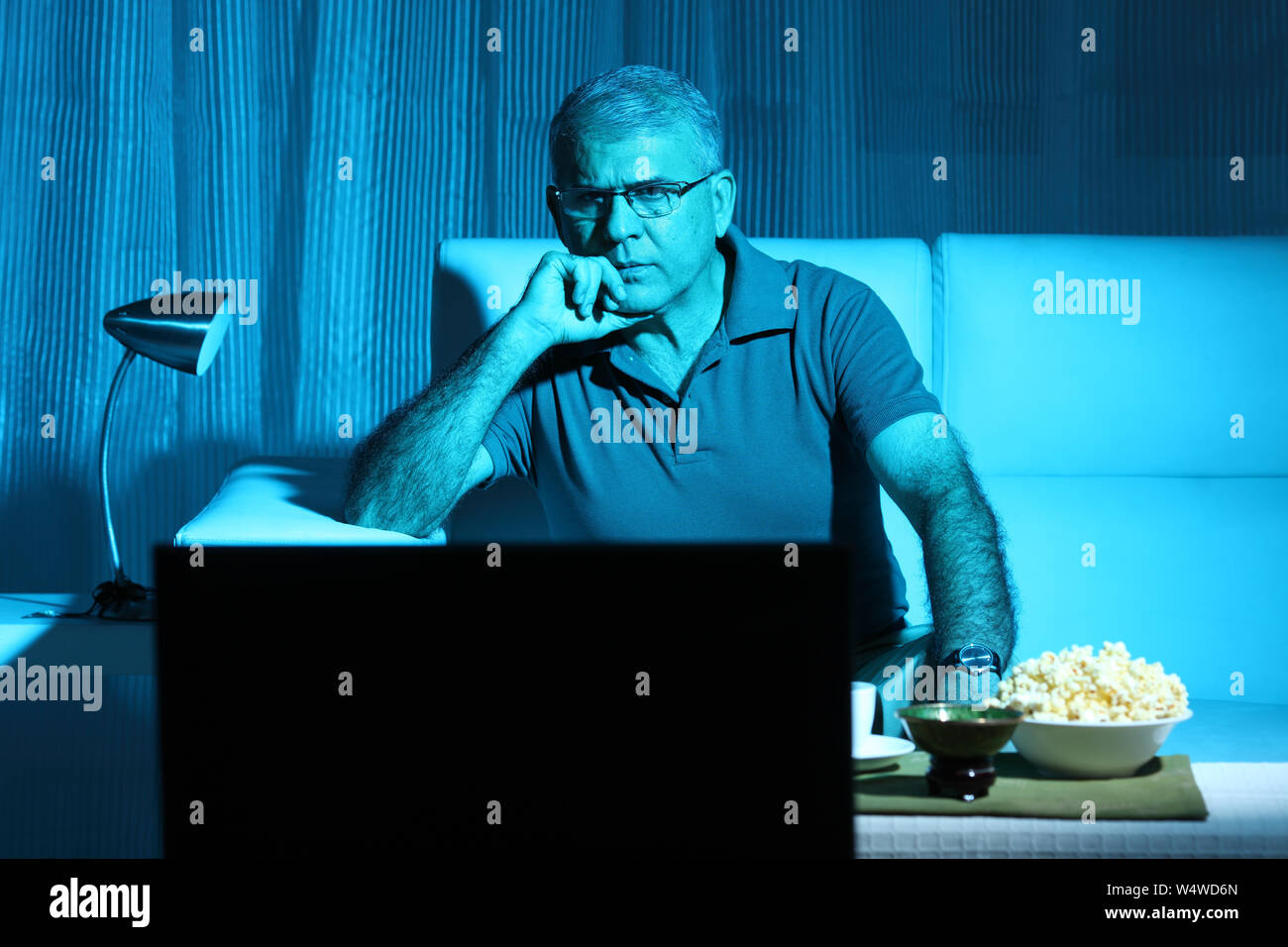 Indian old man sitting on a couch watching television Stock Photo - Alamy