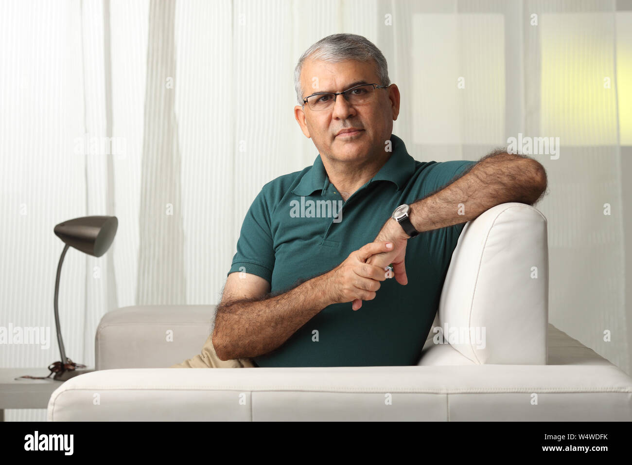 Old man sitting on a couch at home Stock Photo - Alamy