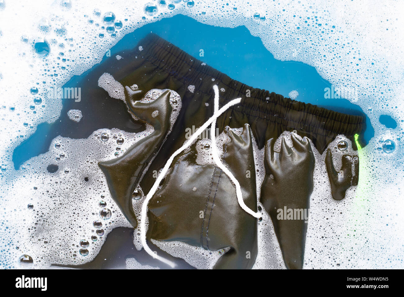Male shorts soak in powder detergent water dissolution, washing cloth ...