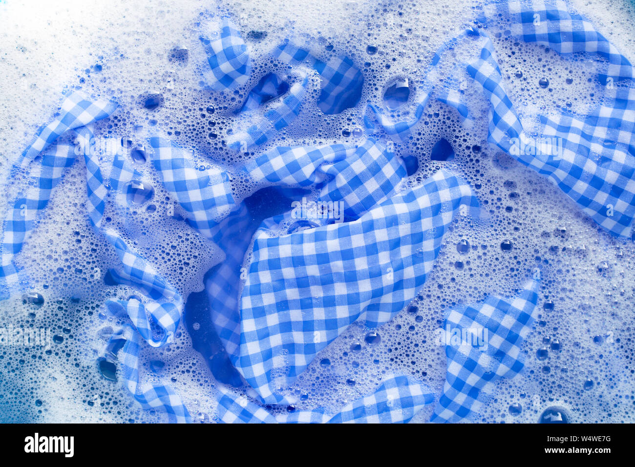 Blue white tablecloth soak in powder detergent water dissolution ...