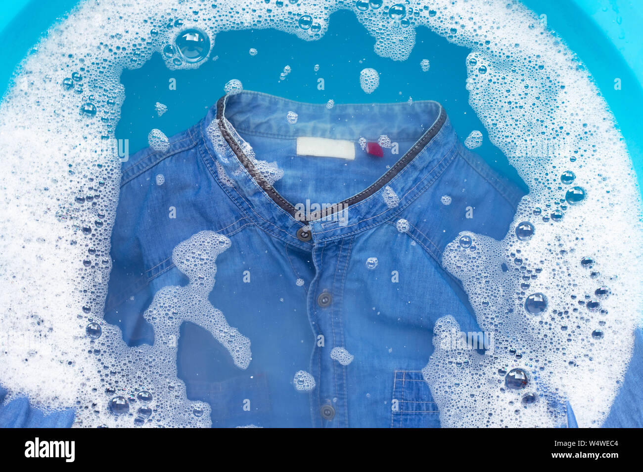 Jean shirt soak in powder detergent water dissolution, washing cloth ...