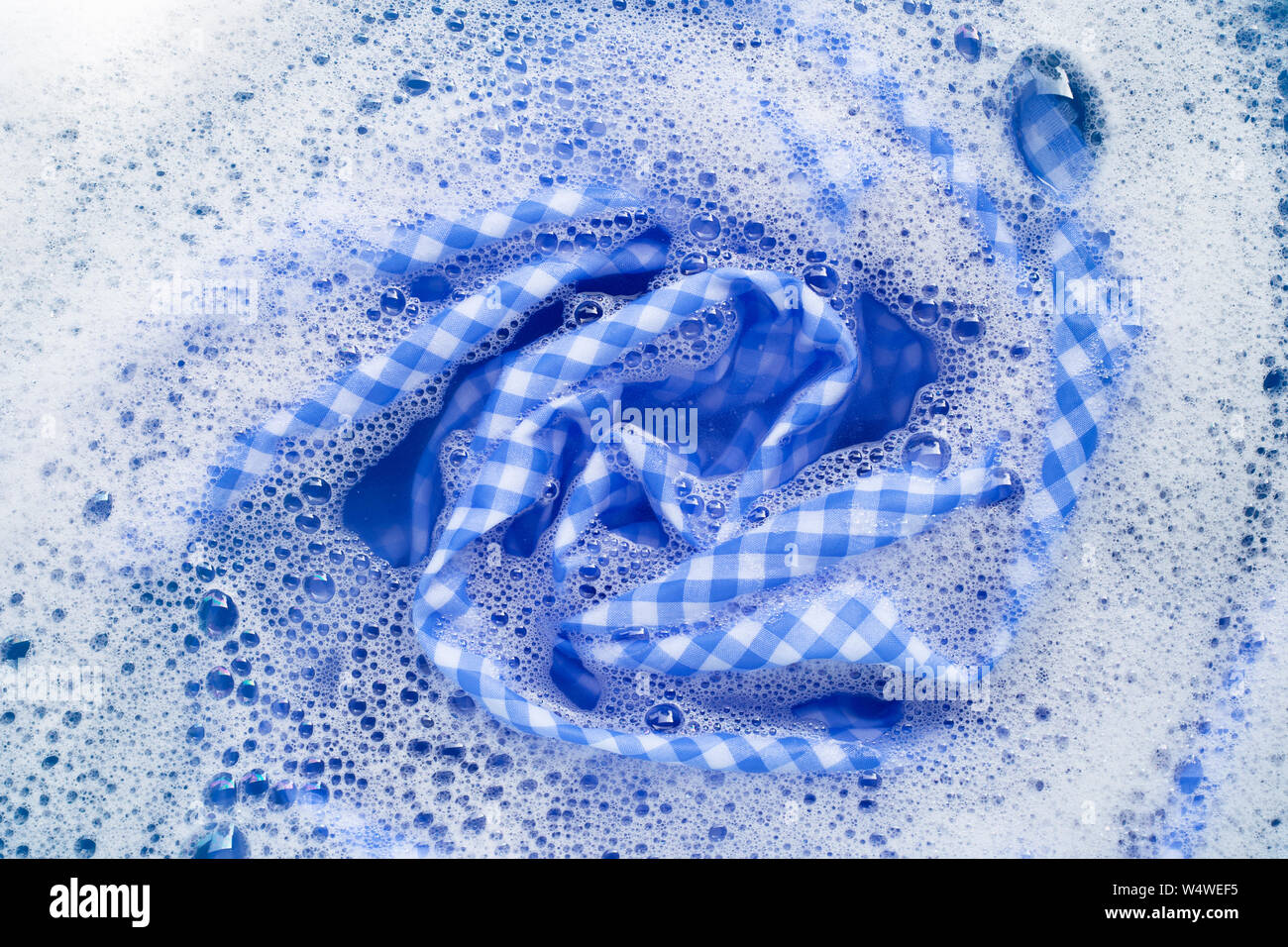 Blue white tablecloth soak in powder detergent water dissolution ...
