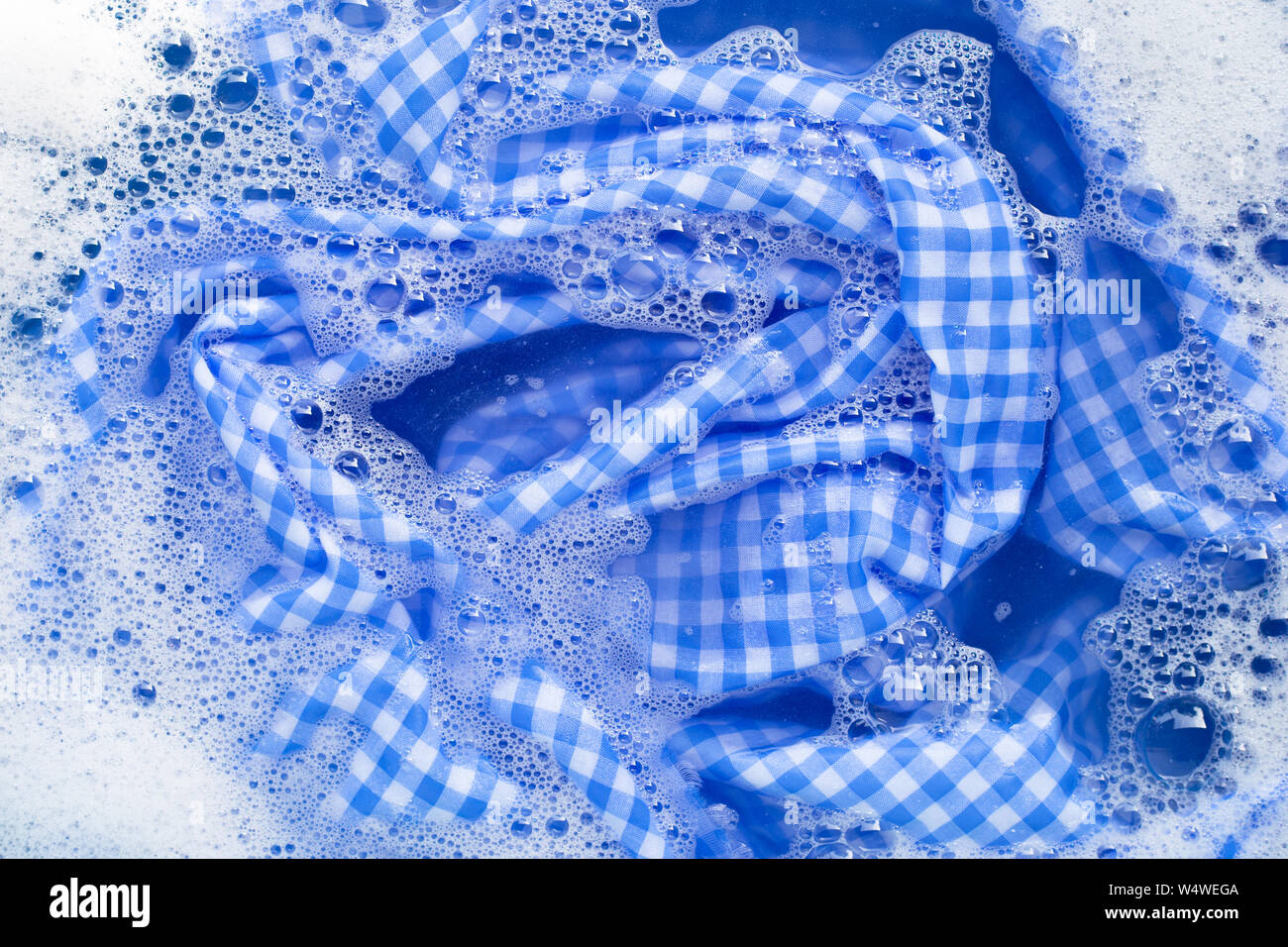 Blue white tablecloth soak in powder detergent water dissolution ...