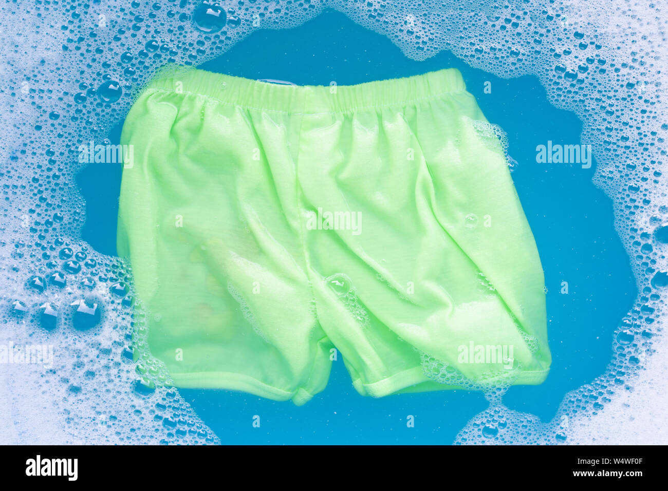 Green baby shorts soak in baby laundry detergent water dissolution ...