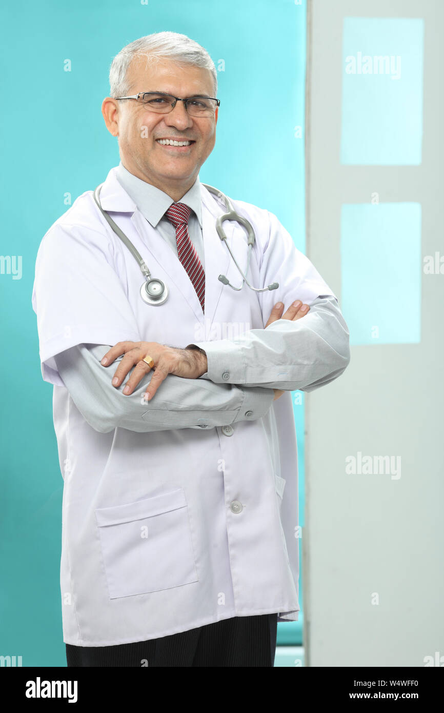 Male doctor standing with his arms crossed and smiling Stock Photo - Alamy