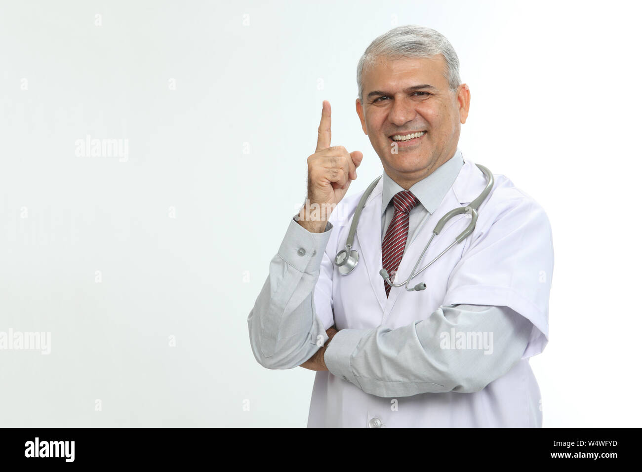 Male doctor pointing upward and smiling Stock Photo - Alamy