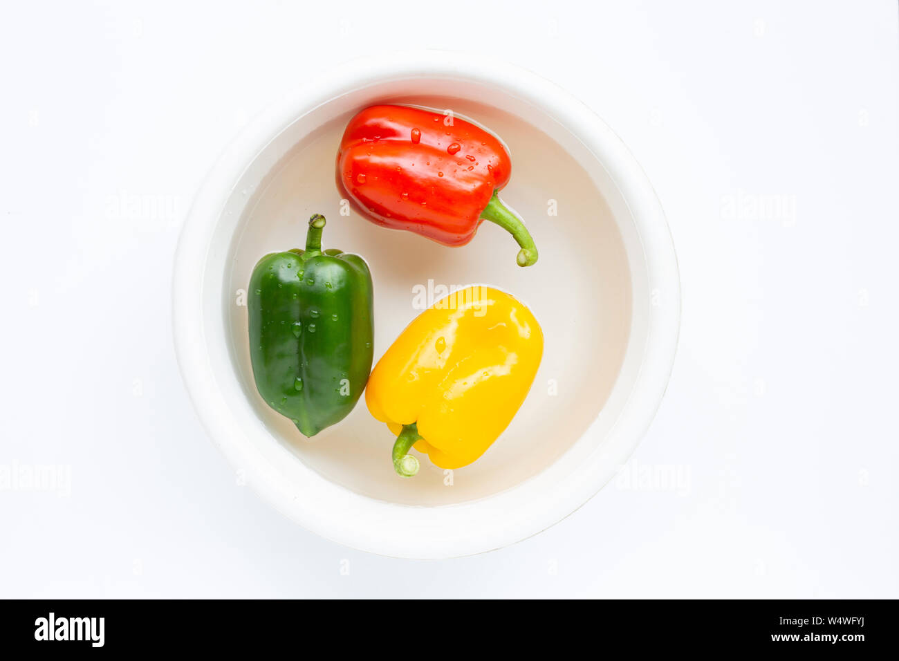 Bell pepper soaked in water. Washing fresh vegetables on white ...