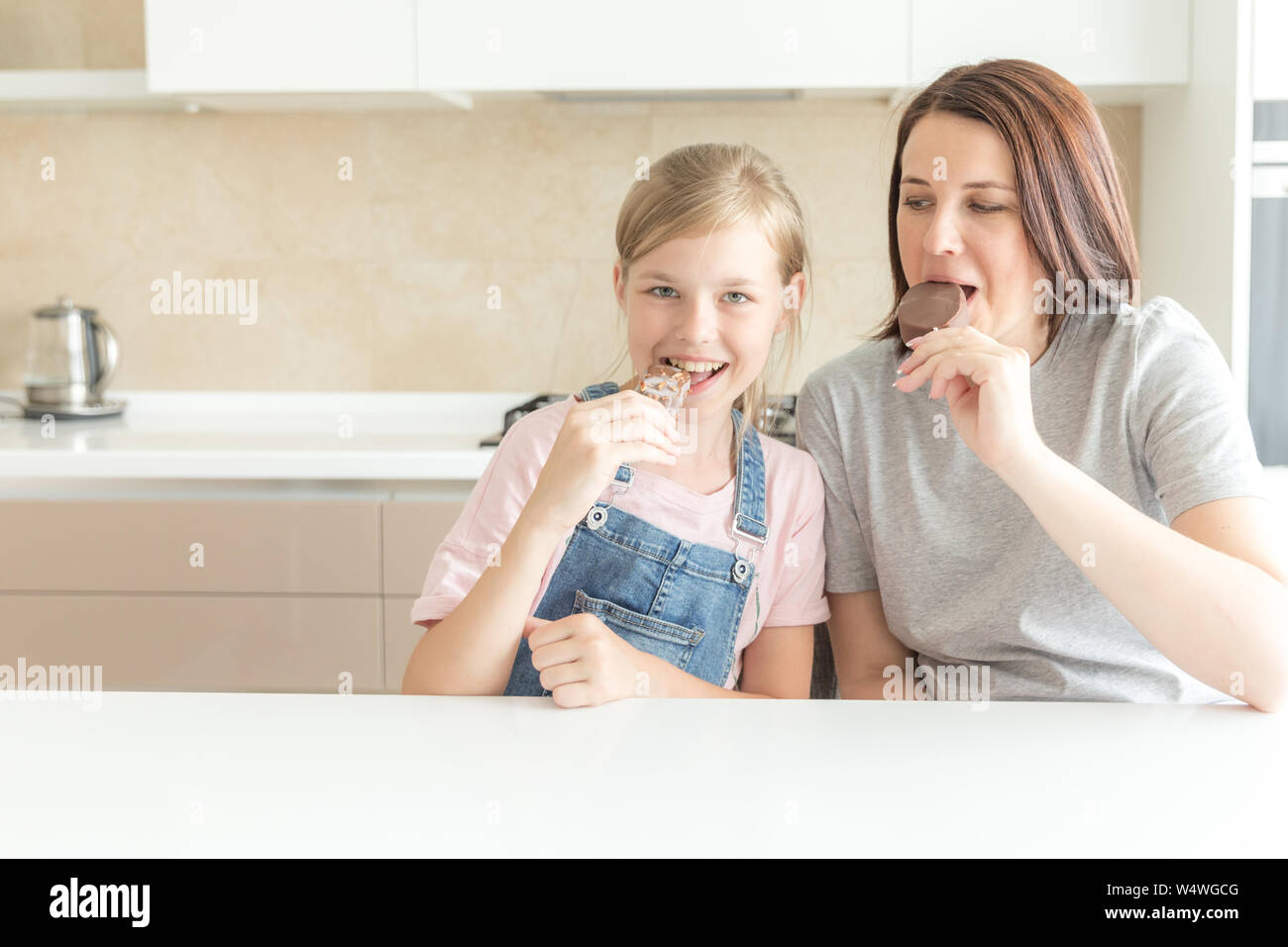 Mother With Daughter In Kitchen Eating Ice Cream Good Relations Of